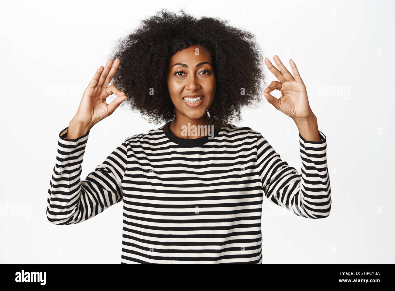 Okay, very good. Smiling african american female model, showing ok ...