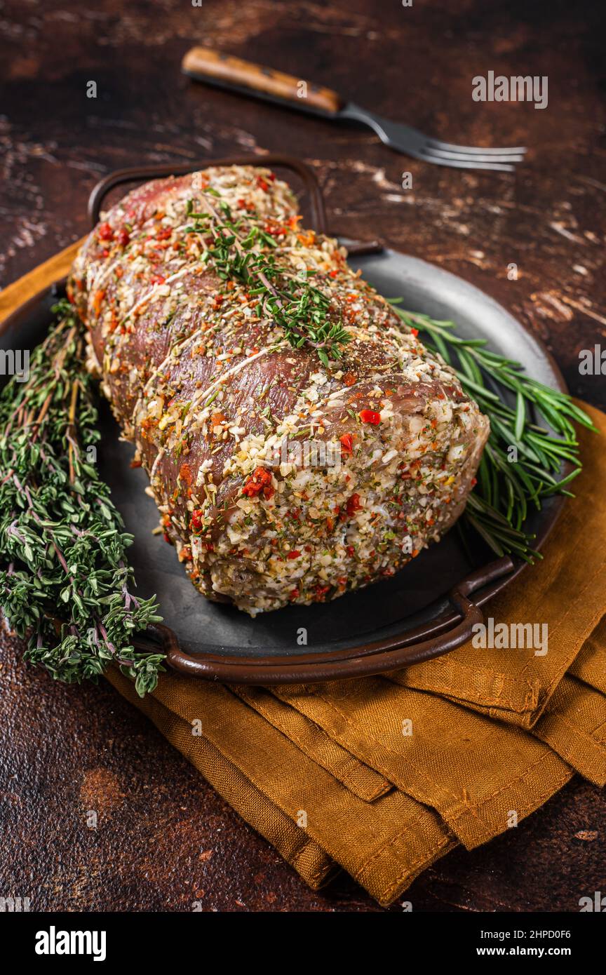 Rolled meat pork roulade with rosemary and thyme. Dark background. Top ...