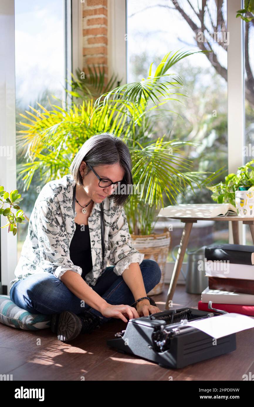 Adult woman typing on the terrace of her house. Time for inspiration ...