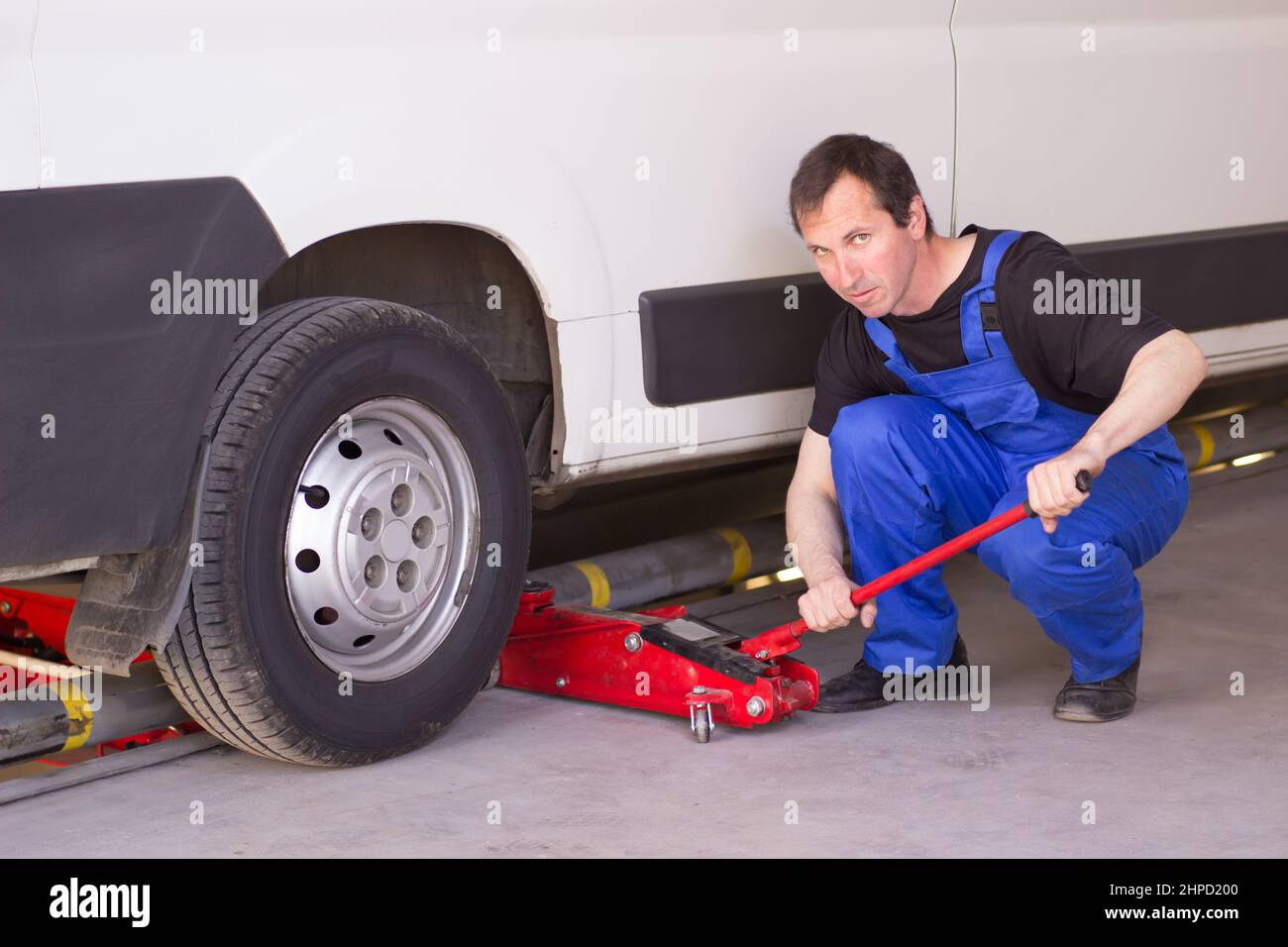 Mechanic uses jackscrew in the auto service Stock Photo - Alamy