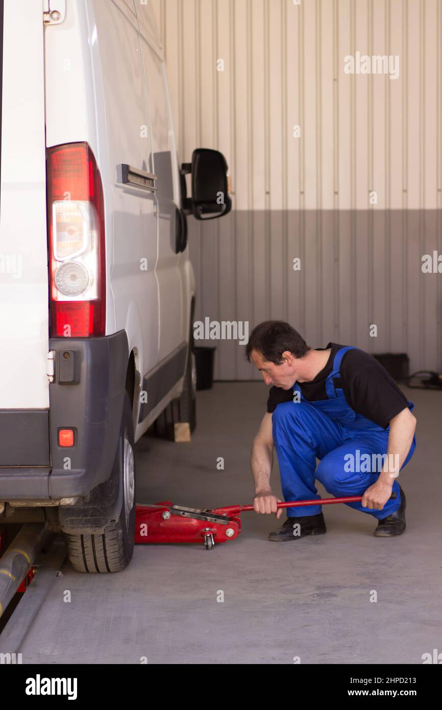 Mechanic uses jackscrew in the auto service Stock Photo - Alamy