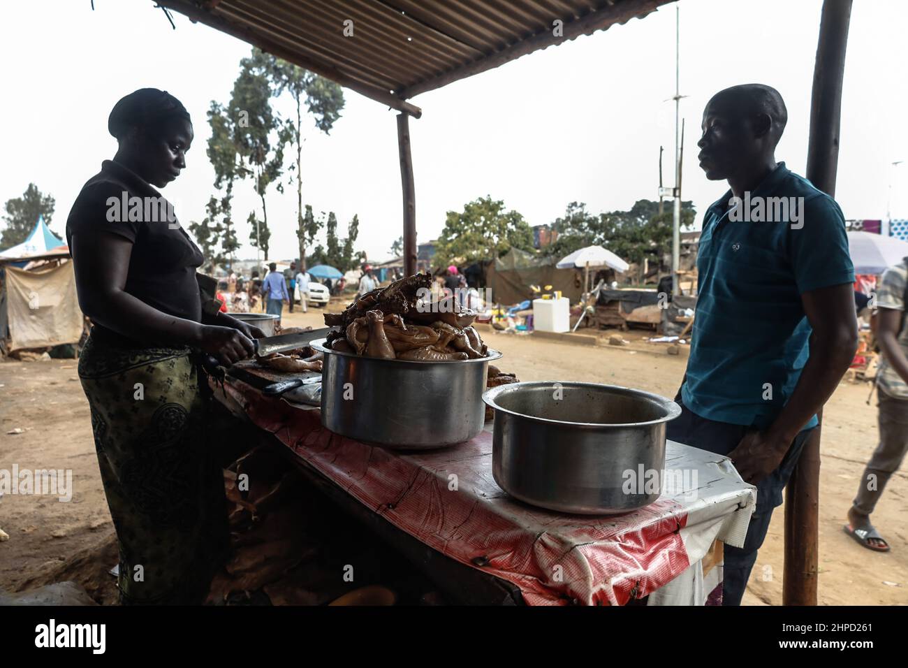 A woman sells fried chicken by the streets in Kibera Slums. Inside ...