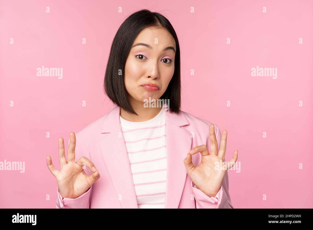Not bad. Impressed businesswoman, asian office lady showing okay sign ...