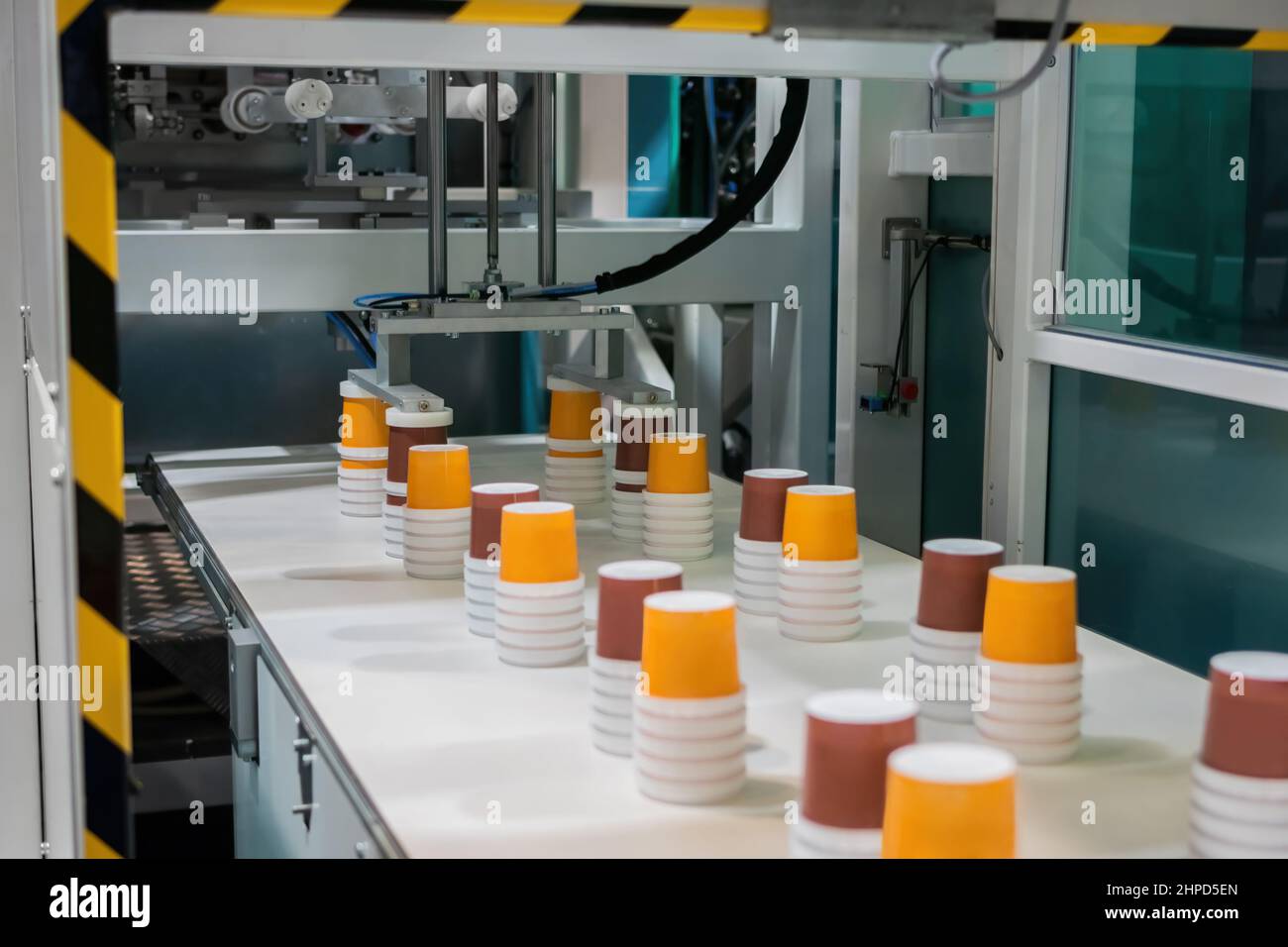 Empty plastic cups moving on conveyor belt at package exhibition Stock ...