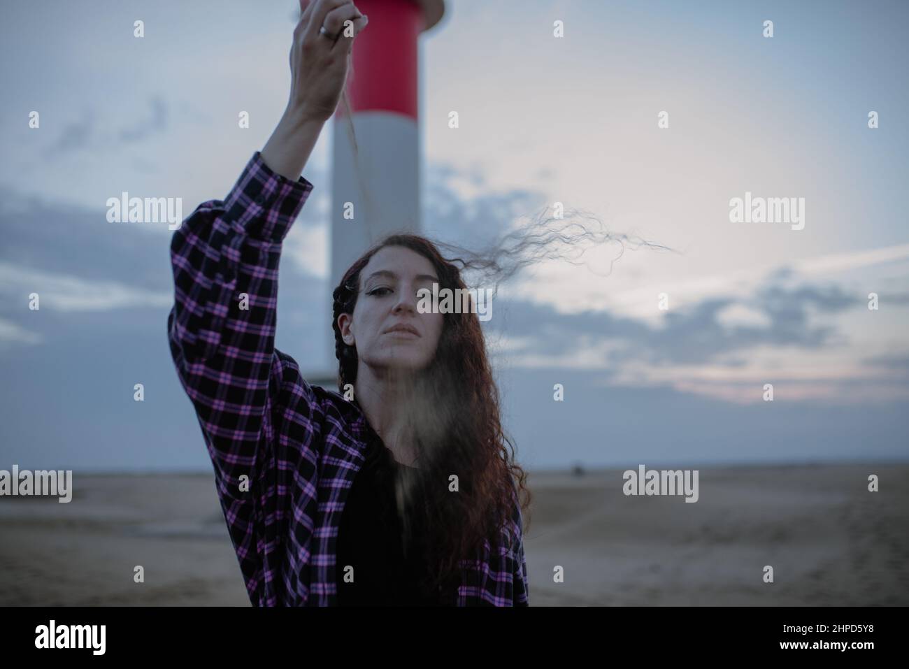 Woman dropping a handful of sand in front of her face. Time and lost ...
