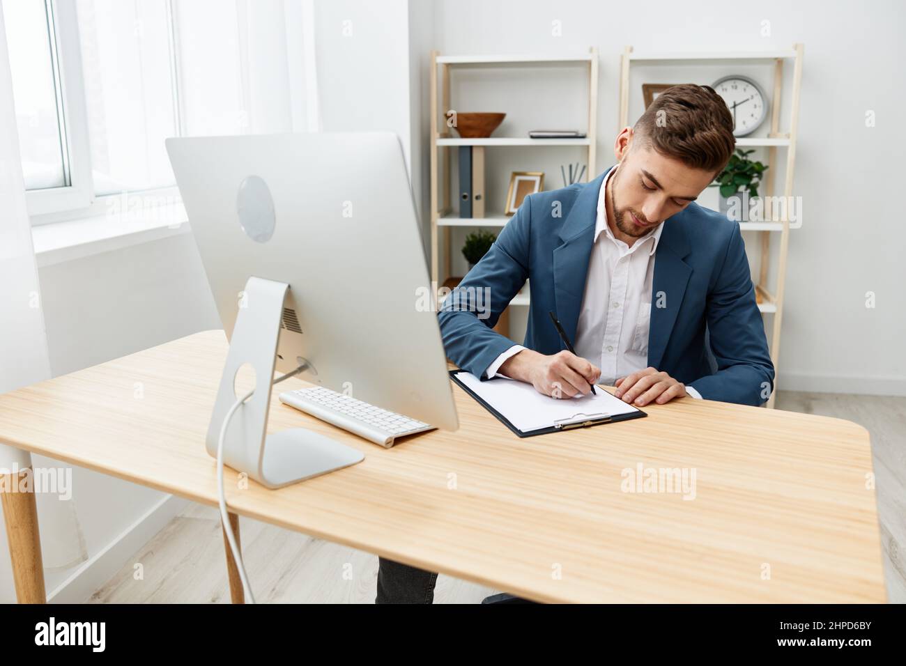 manager writes in documents at the desk in the office isolated ...