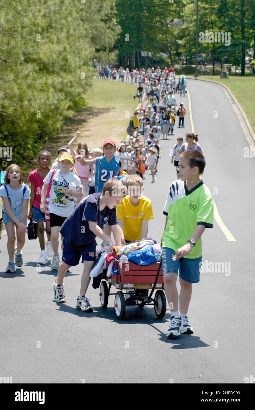 Line of school kids going to park for lunch in spring with teachers ...