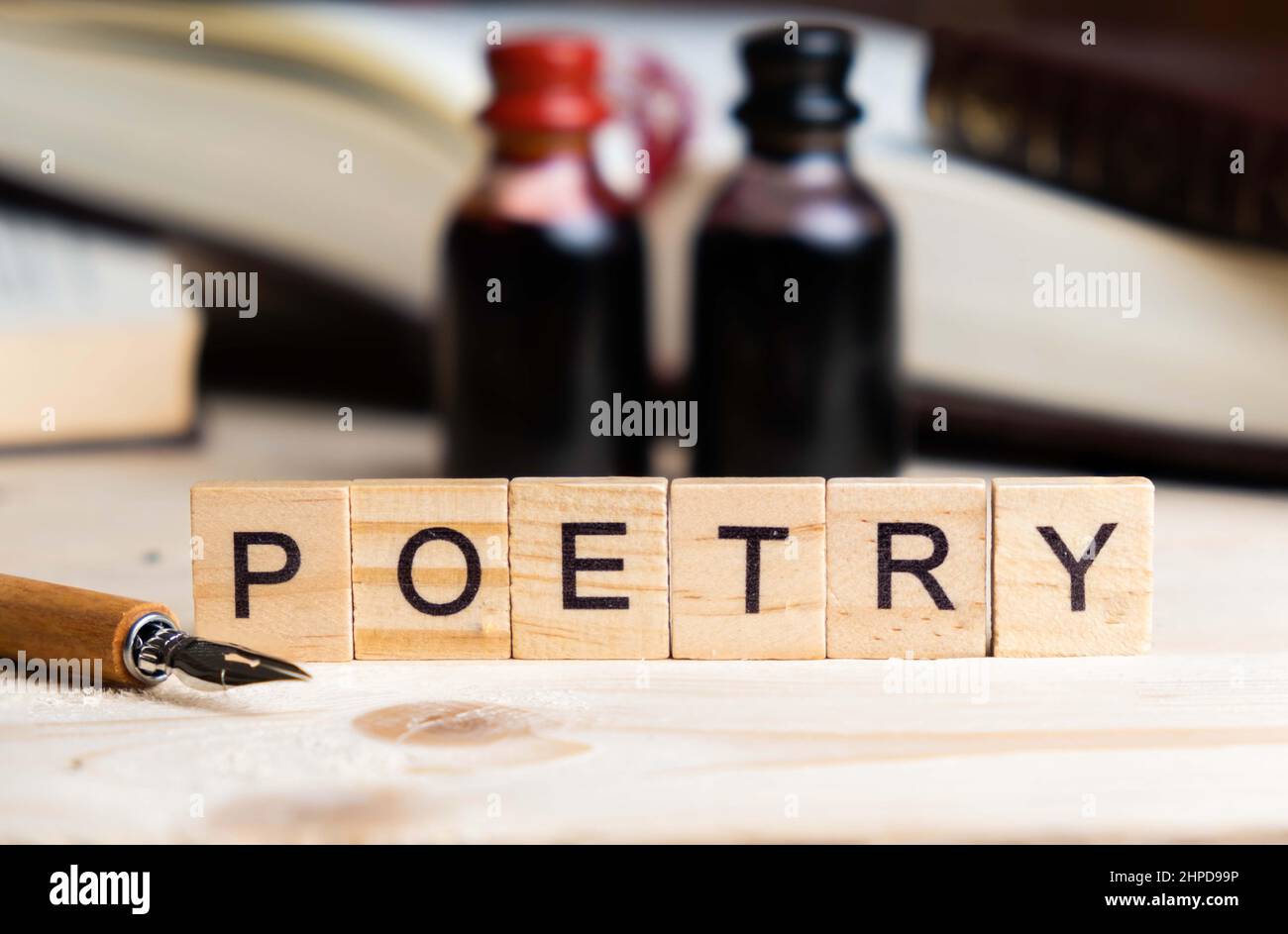 Word POETRY with wooden blocks, with a quill, ink and books ...
