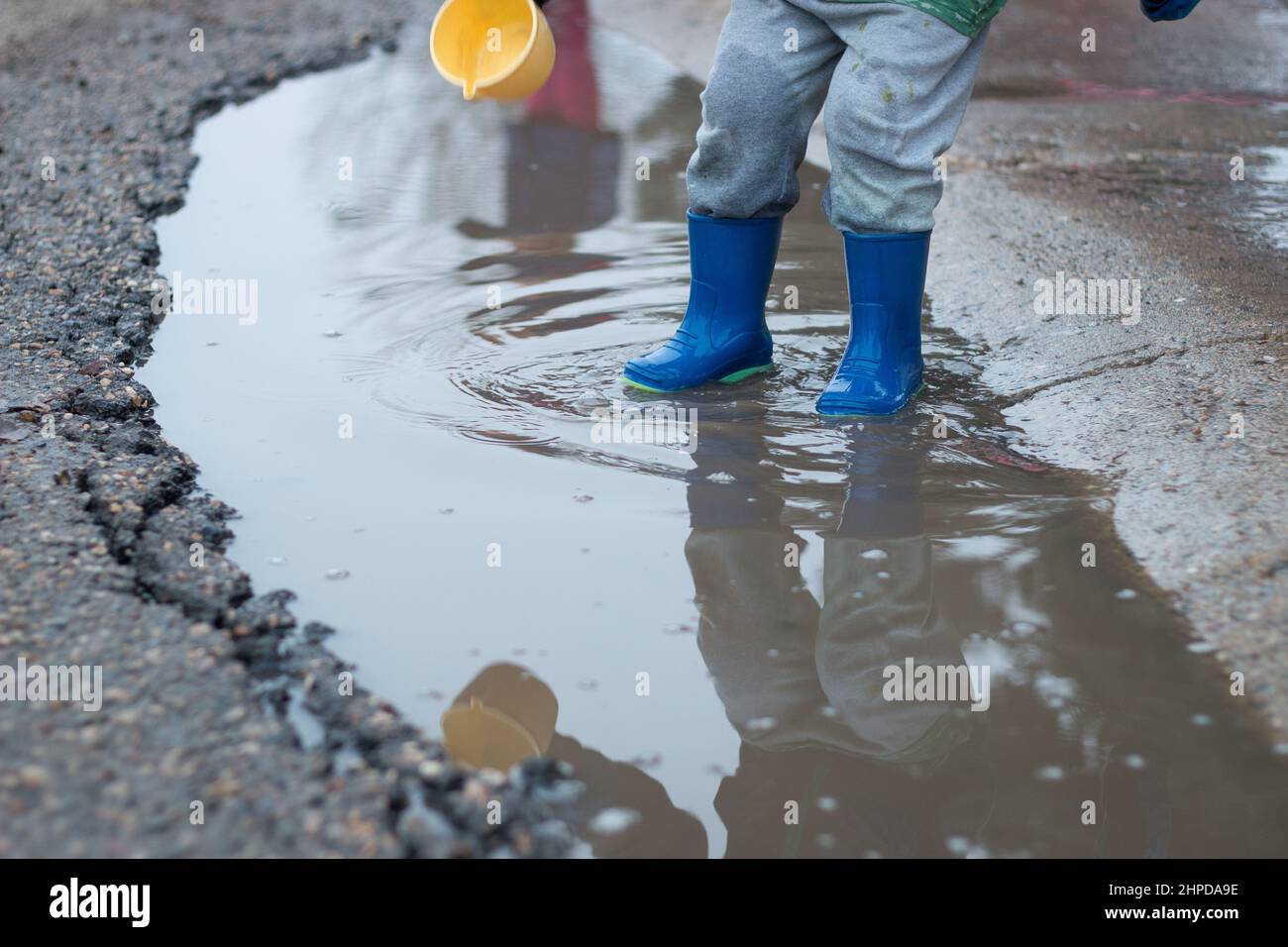 Little boy playing in the puddles Stock Photo - Alamy