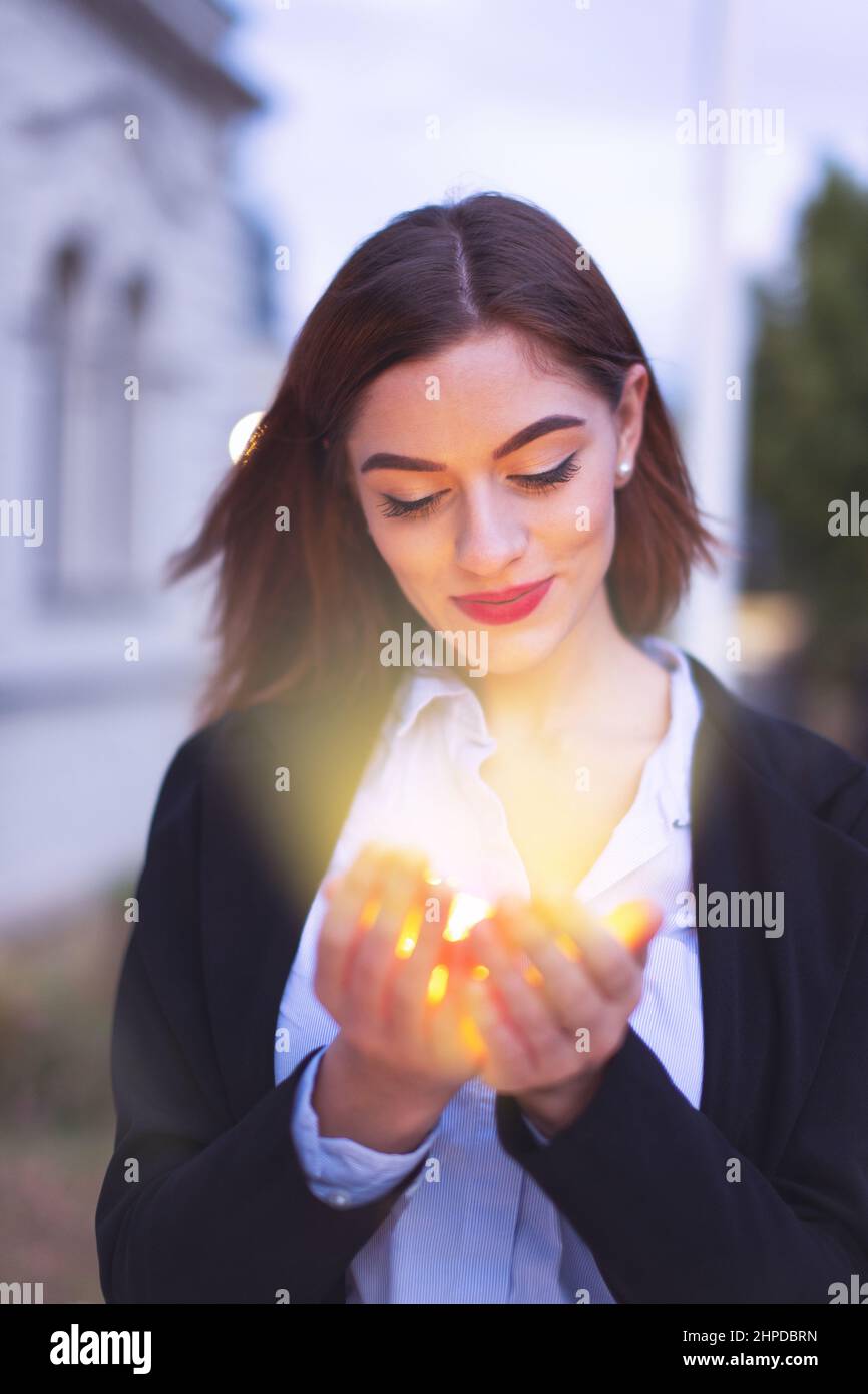 Young woman holding glowing treasure outdoors, looking down Stock Photo ...
