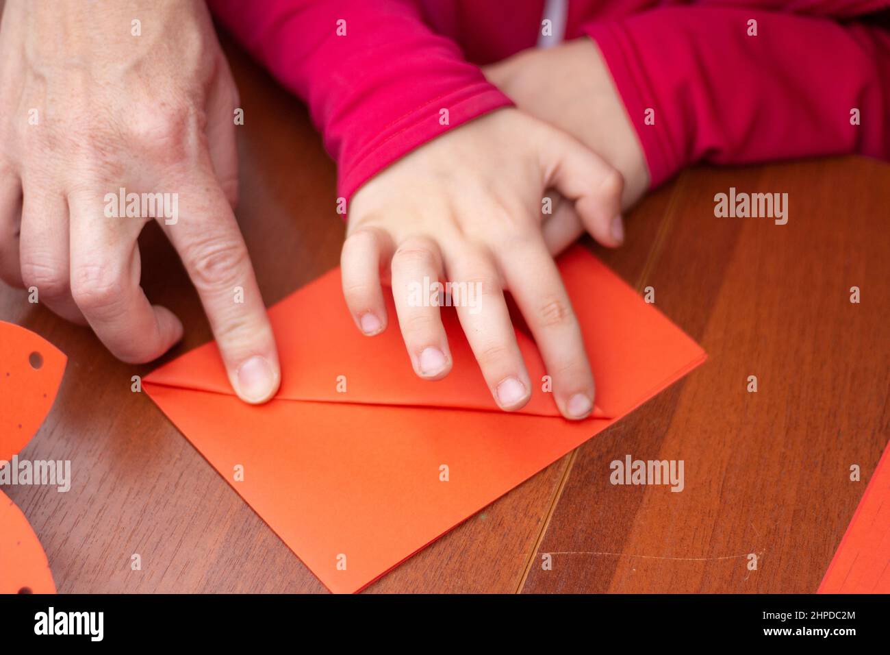 Folding paper. Lesson in children's creativity. Child and adult create ...