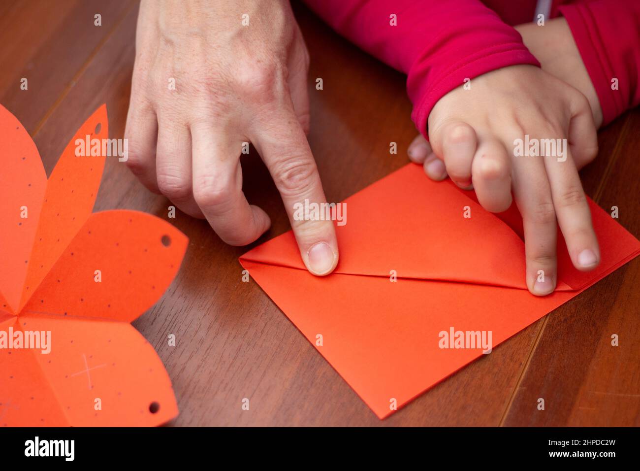 Folding paper. Lesson in children's creativity. Child and adult create ...