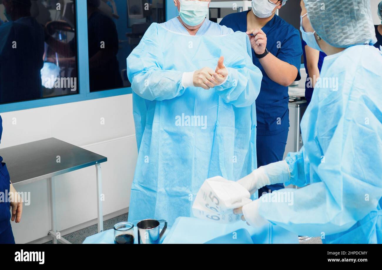 Surgeons dress in sterile blue uniforms before surgery. Selective focus ...