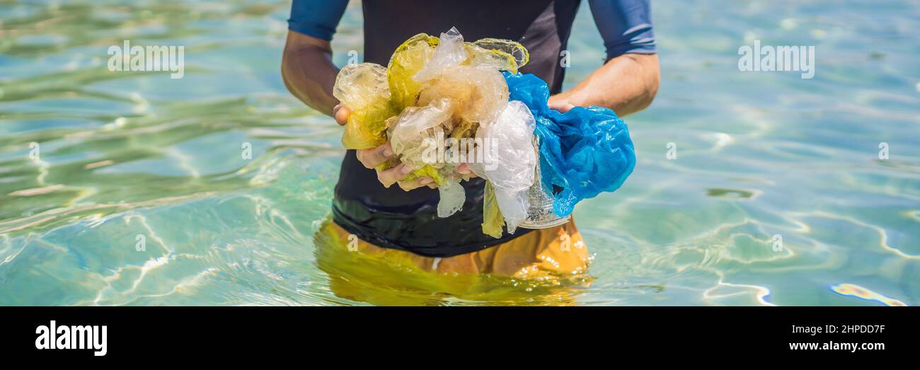 Man collects packages from the beautiful turquoise sea. Paradise beach ...