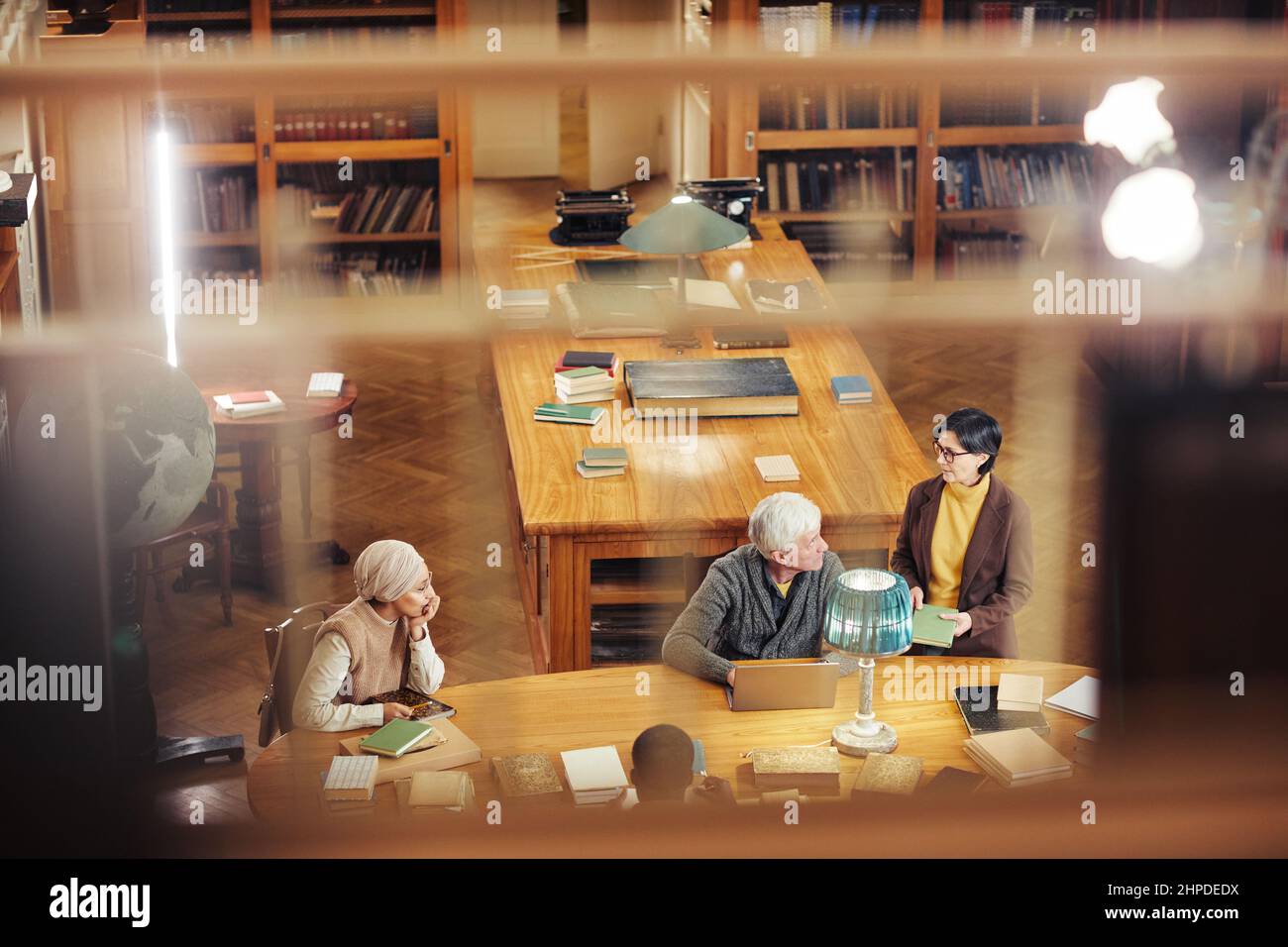 Background image of classic library interior with diverse group of ...