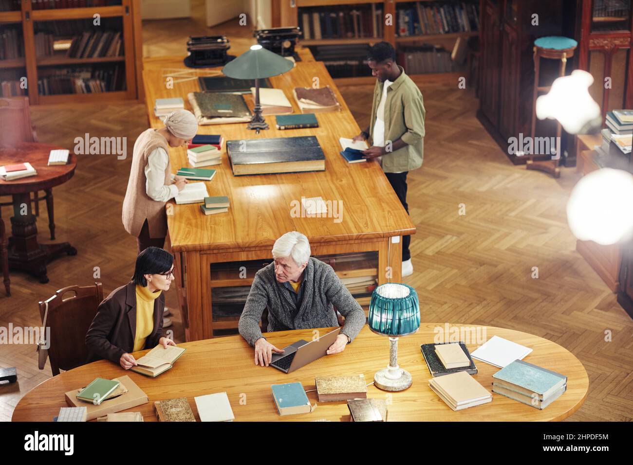 Background image of classic library interior with diverse group of ...