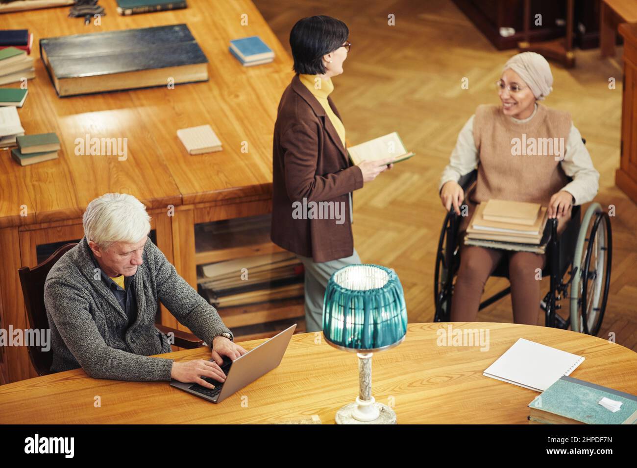 High angle background of classic library interior with diverse group of ...