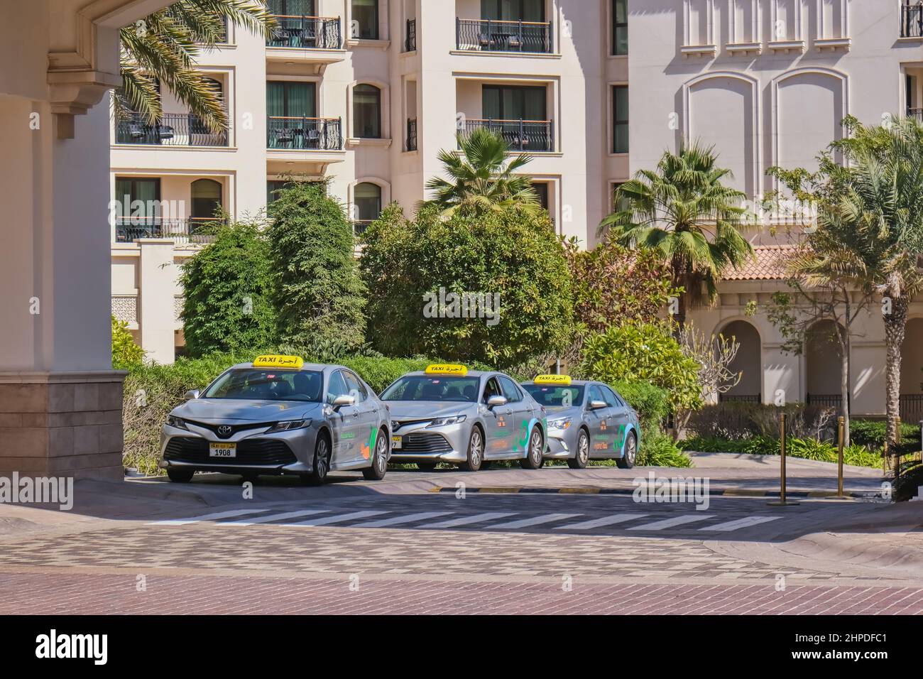 Abu Dhabi urban silver taxis with yellow roof sign lined up at parking ...