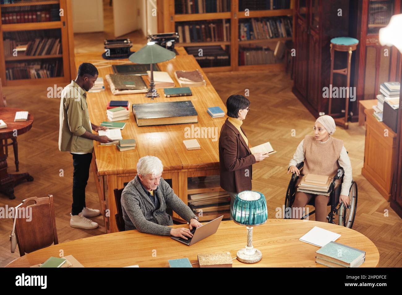 High angle background image of classic library interior with group of ...