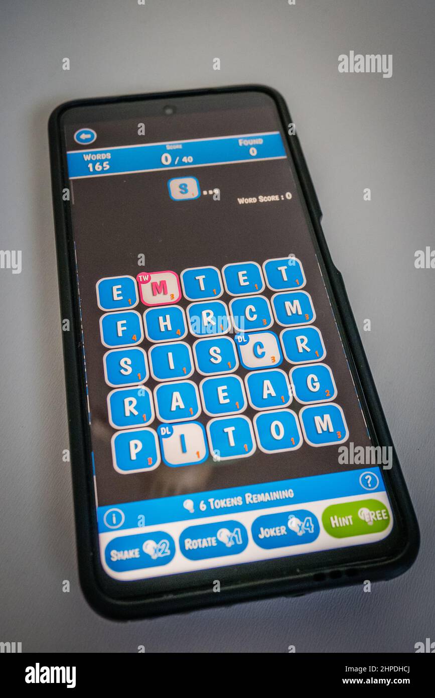 Wordle game on a smart phone with blue letters and dark background ...