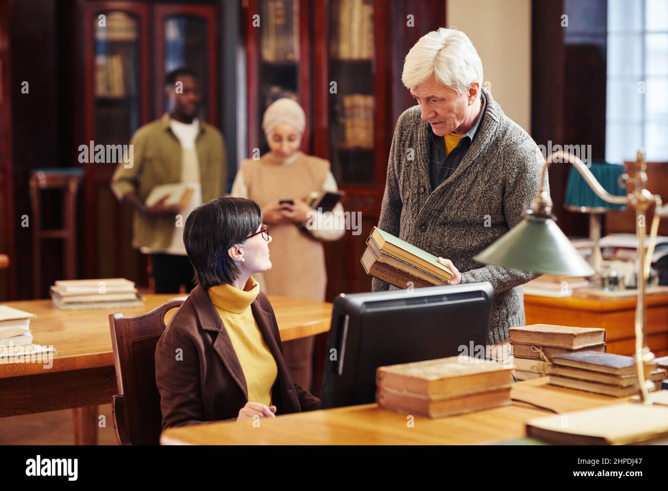 Portrait of two adult people studying together in classic library ...