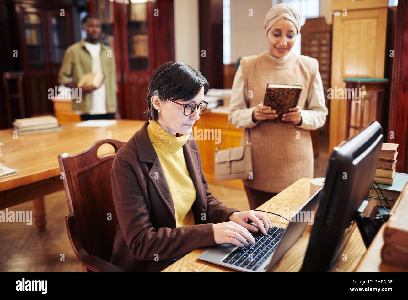 Reading book laptop librarian hi-res stock photography and images - Alamy