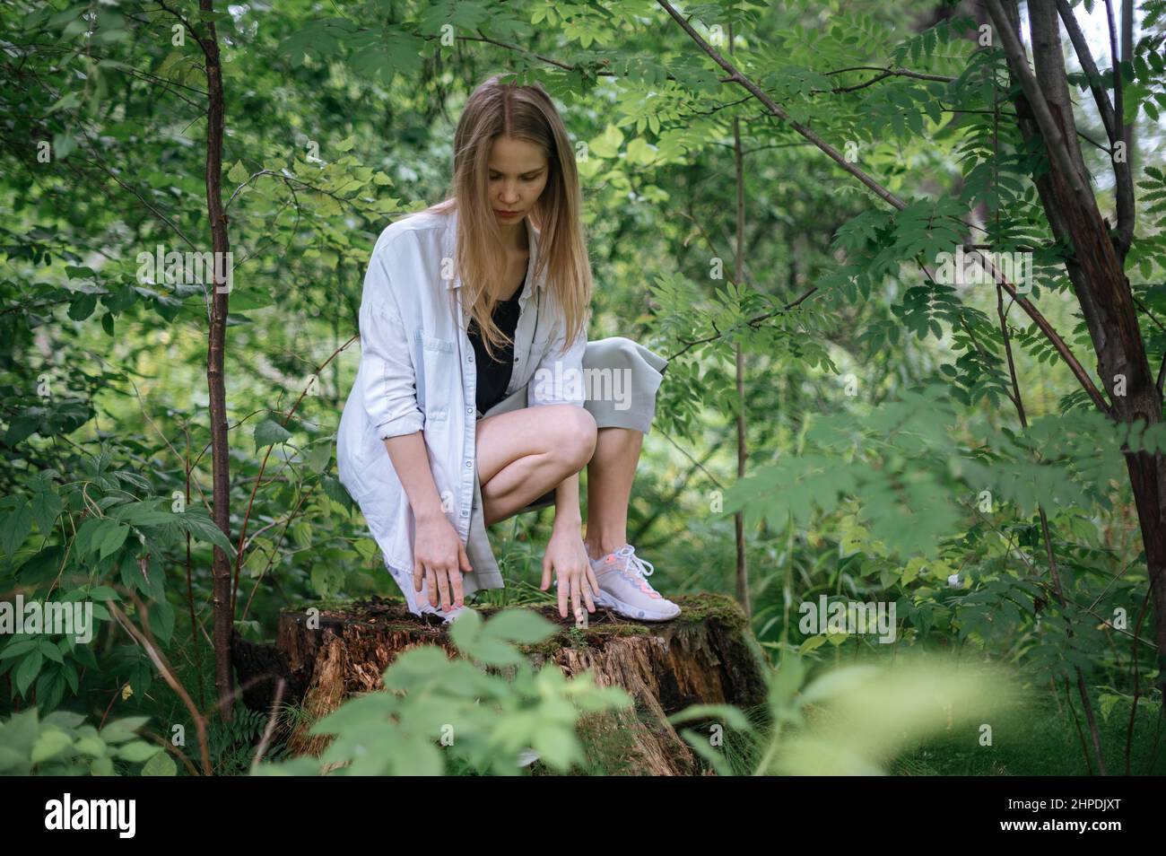 Girl in green forest. Practice of meditation and interaction with ...