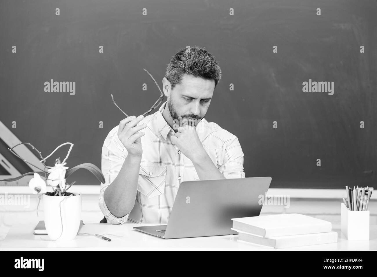 Teacher in classroom at university or college. Male student on board ...