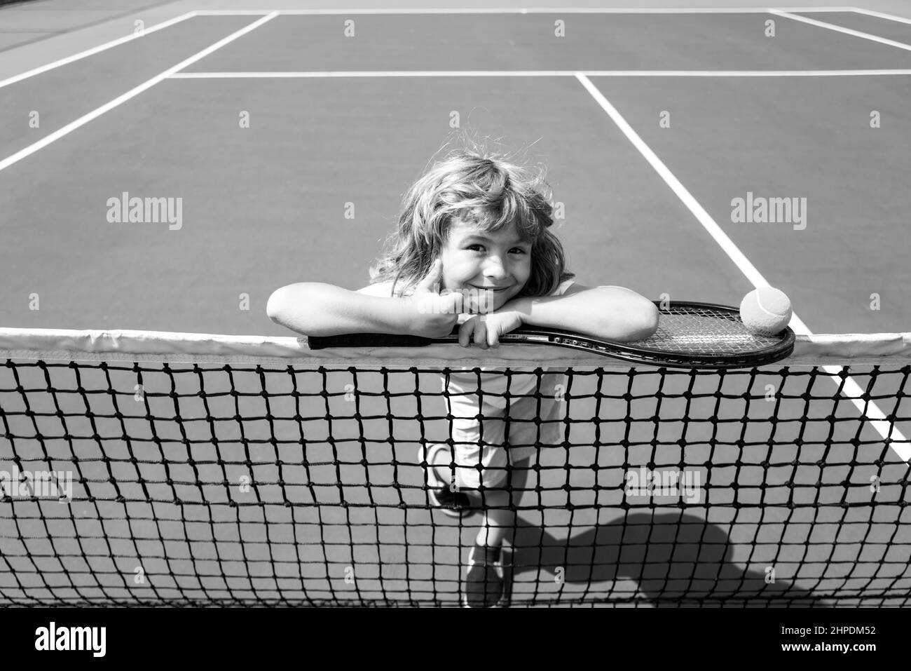 Child boy with tennis racket and ball on tennis court outdoor. Sport ...