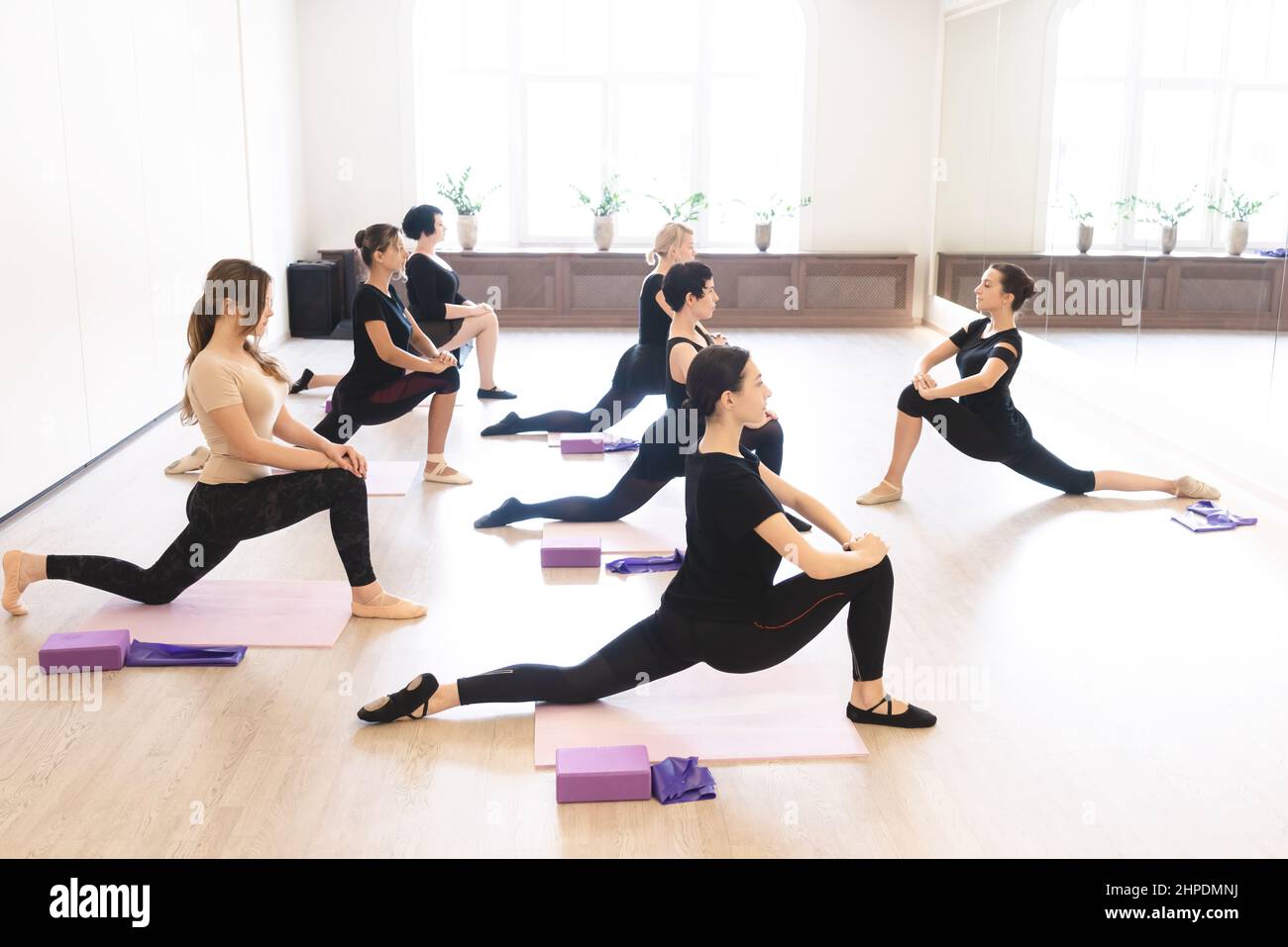 Seven dancer girls warming up with stretching exercises for flexibility ...