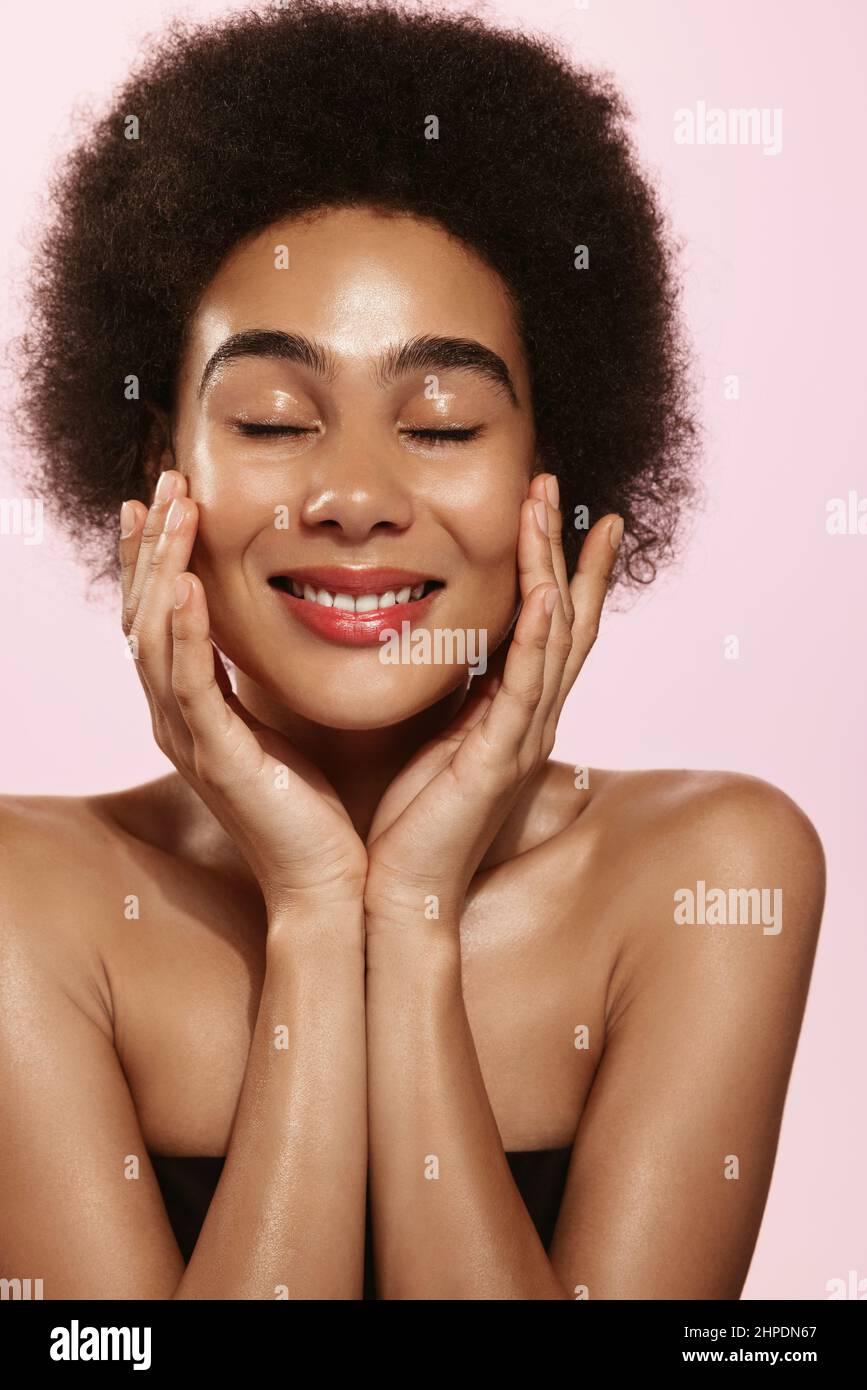 Vertical shot of african american woman model, applying toner, face ...
