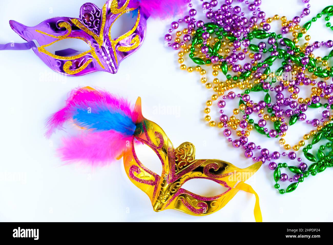 Two carnival masks with feathers and multi-colored beads on white ...