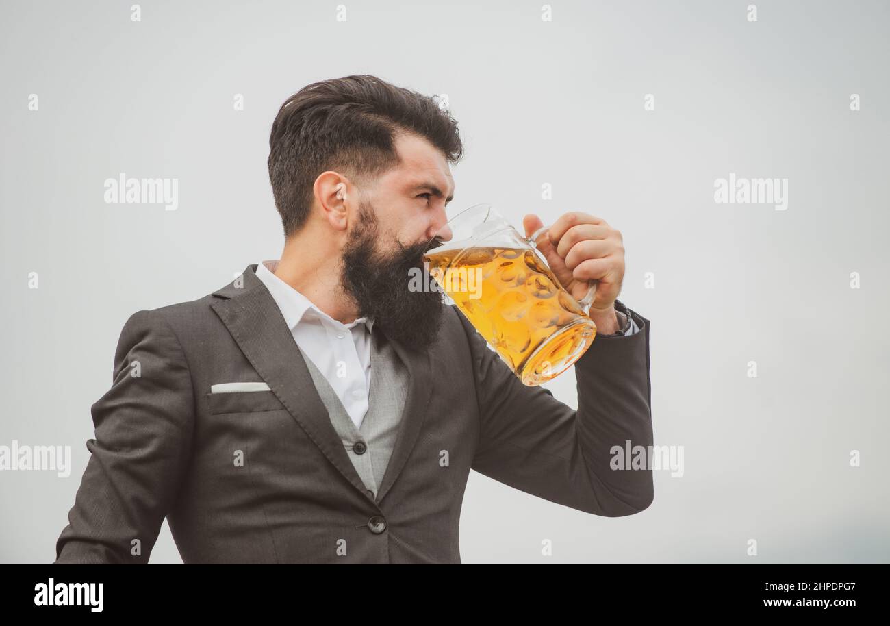 Man in classic suit drinking beer. Portrait of man with big cup of beer ...