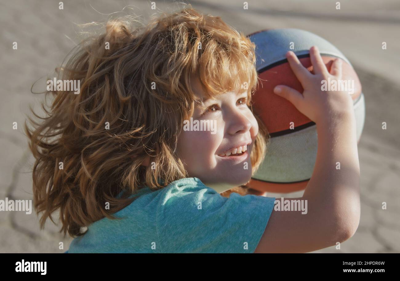 Little caucasian sports kid playing basketball holding ball with happy ...