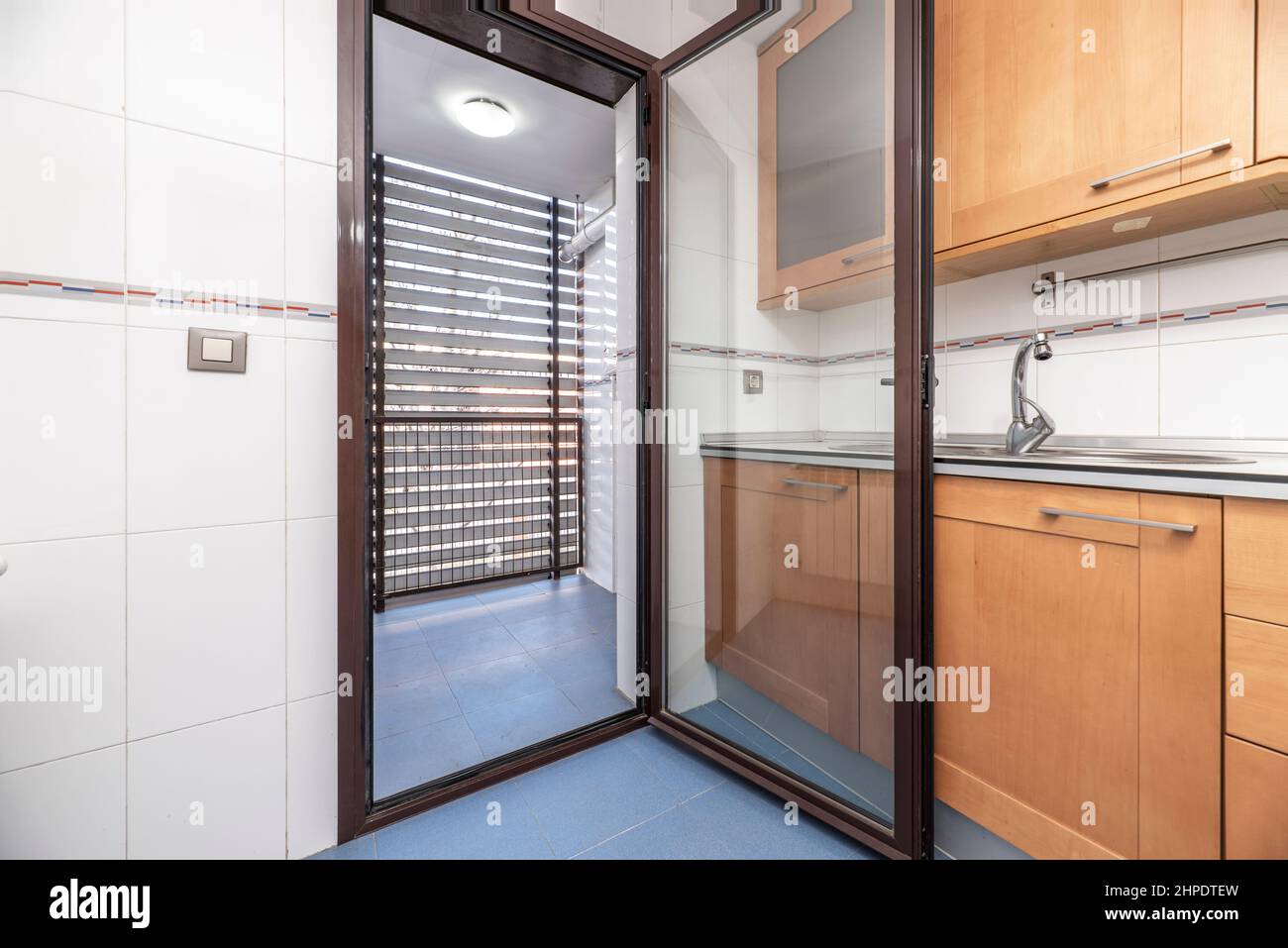 Kitchen with cherry wood furniture and exit to a clothesline terrace ...
