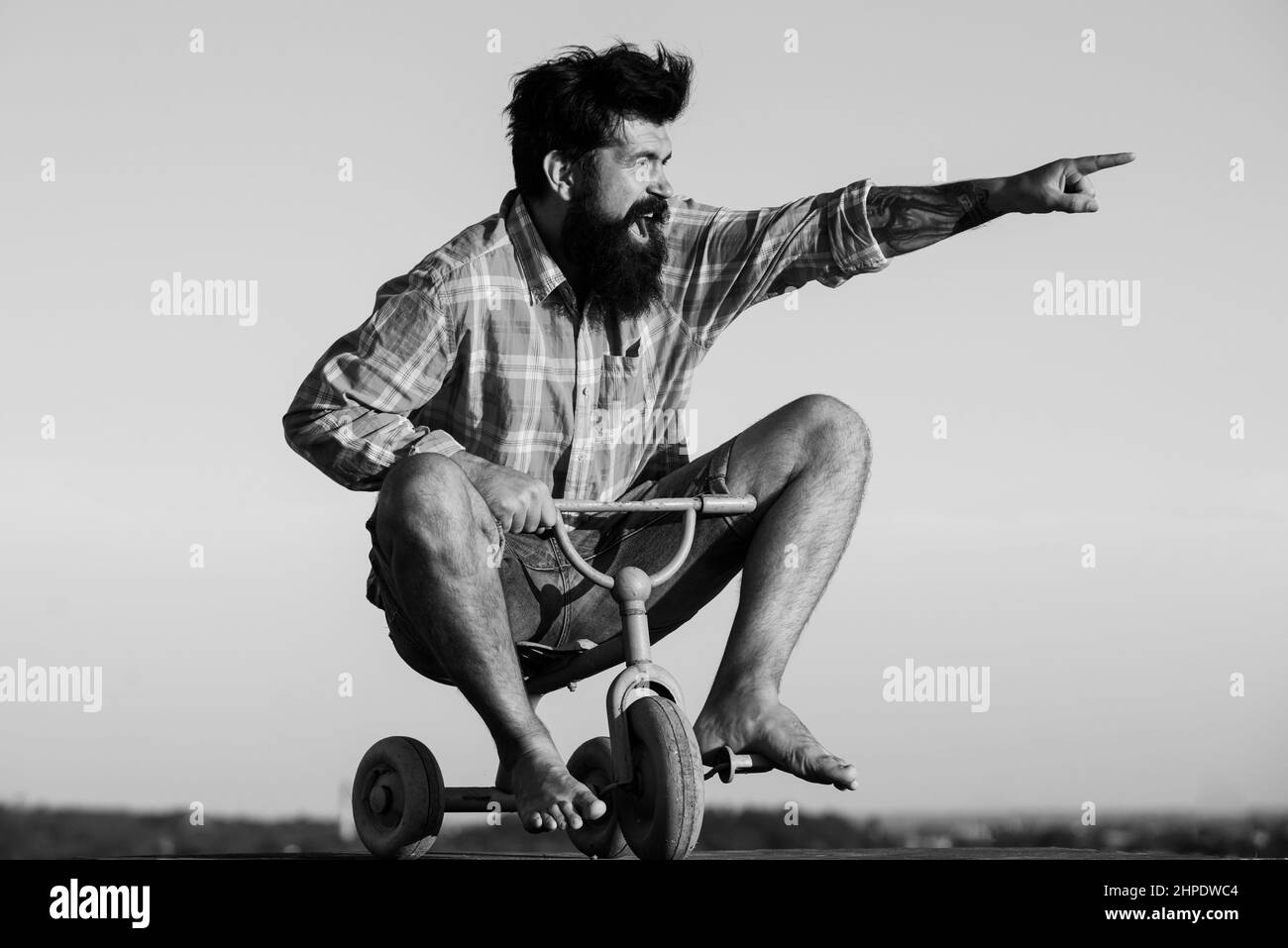 Crazy man riding a small bicycle. Excited young male riding a small ...