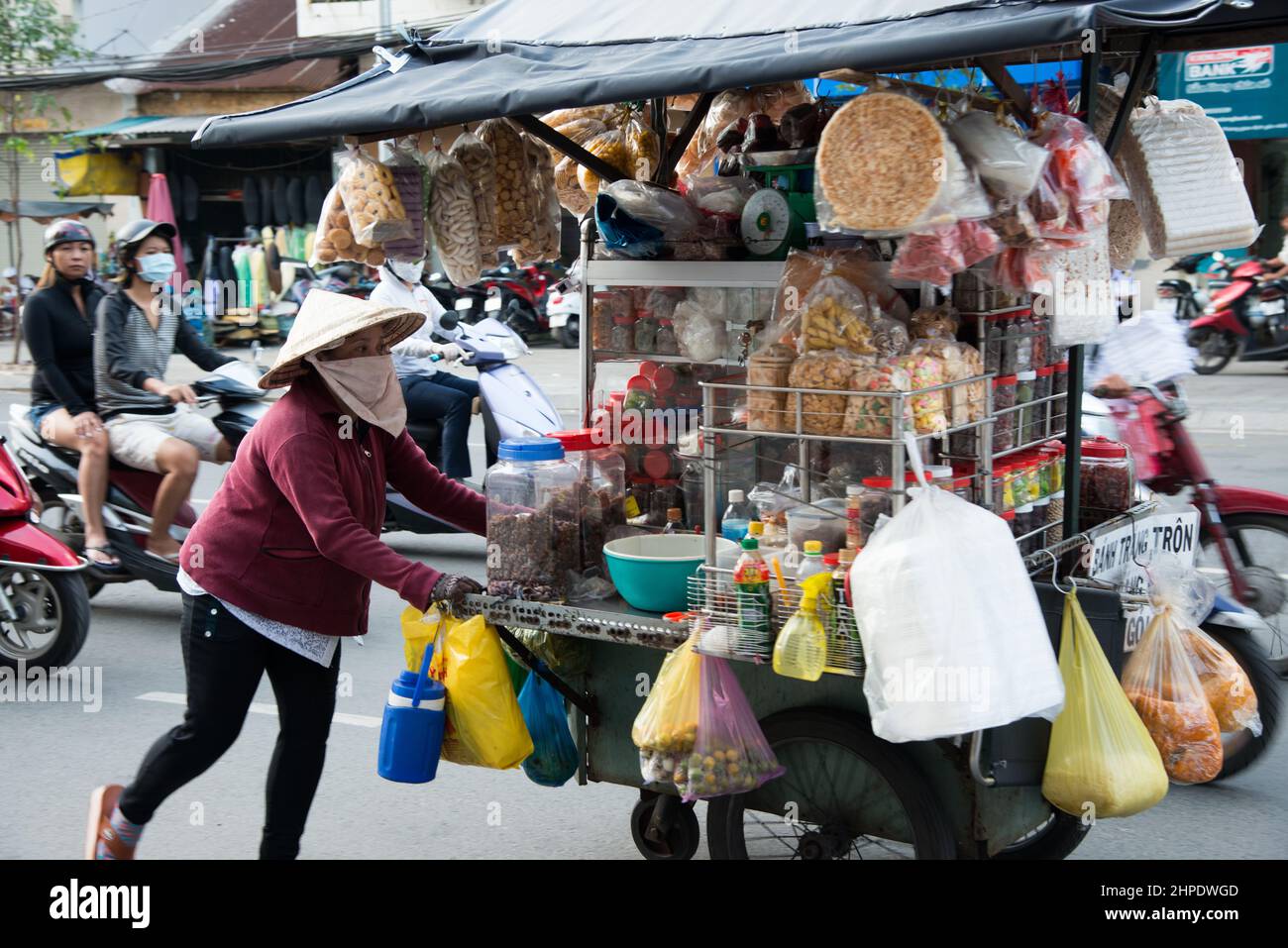 Female pushing a cart with different food by the street in Ho chi minh ...