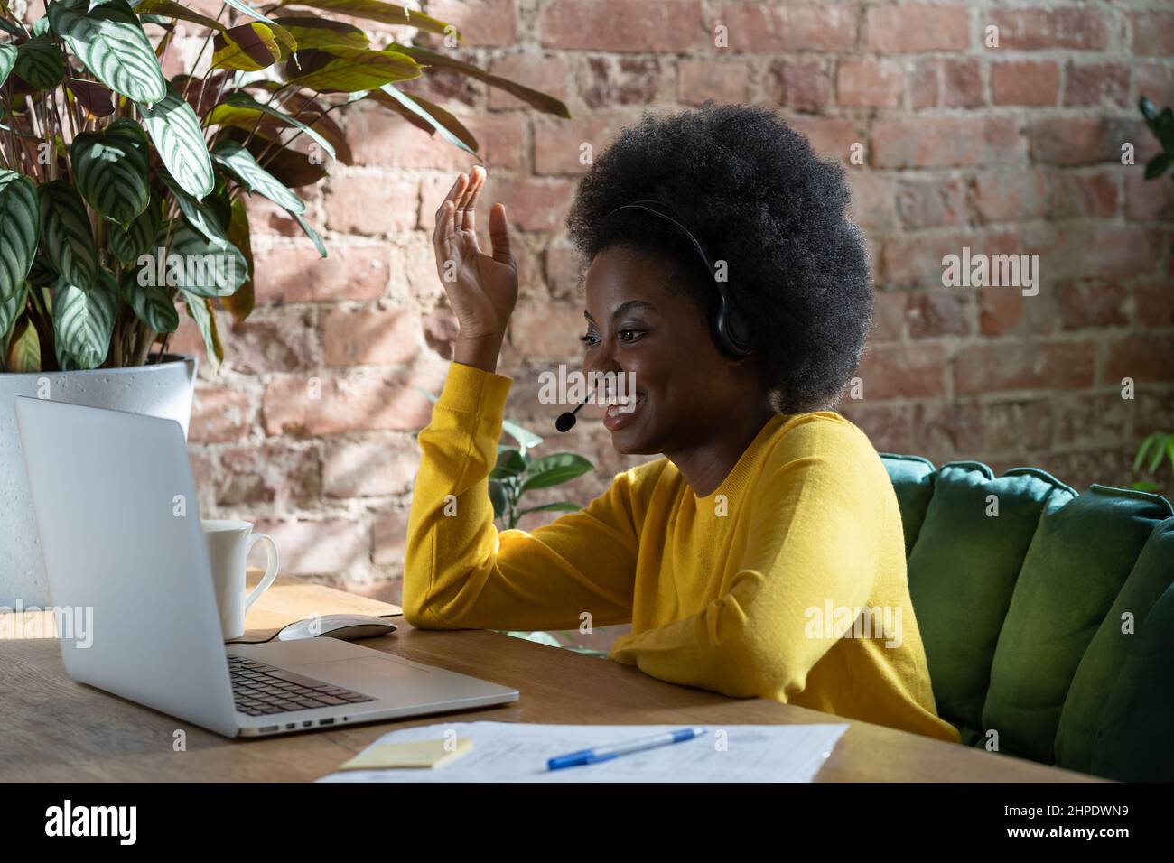 Smiling Afro woman employee talking in video chat with clients on ...