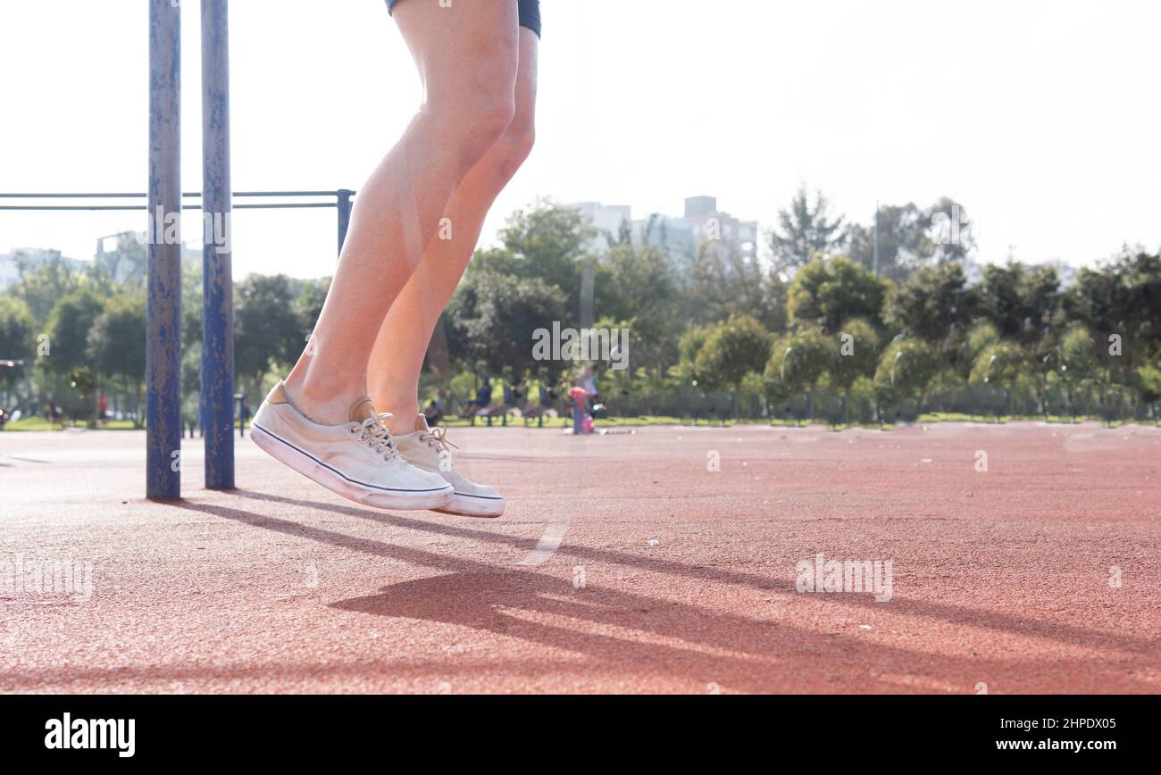 Close-up of a man's legs jumping rope in a park during an outdoor ...