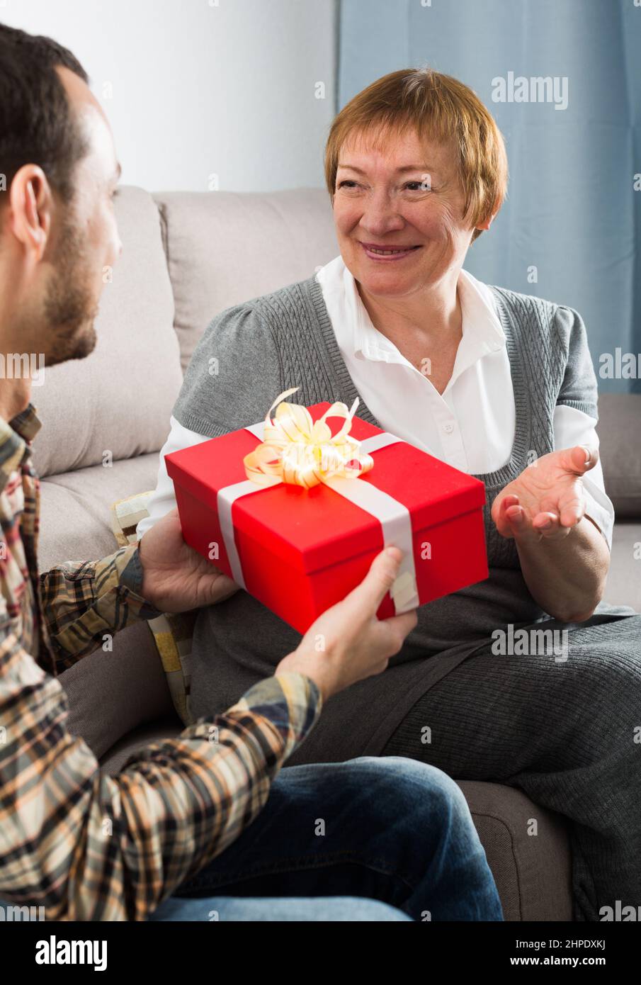 Son giving present to mother Stock Photo - Alamy
