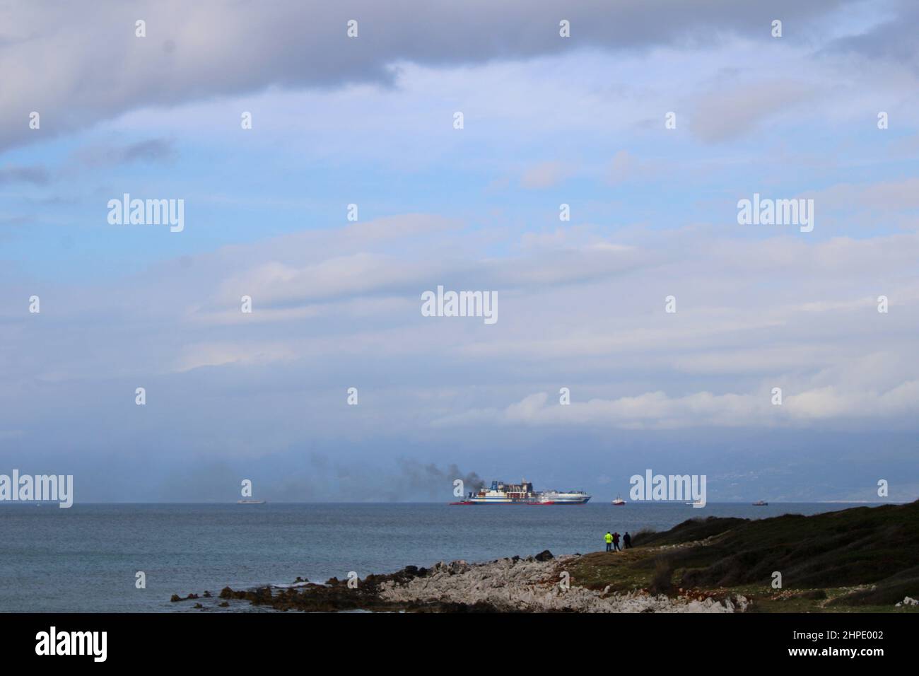 Sightseers watching the burning ferry Euroferry Olympia off the coast ...