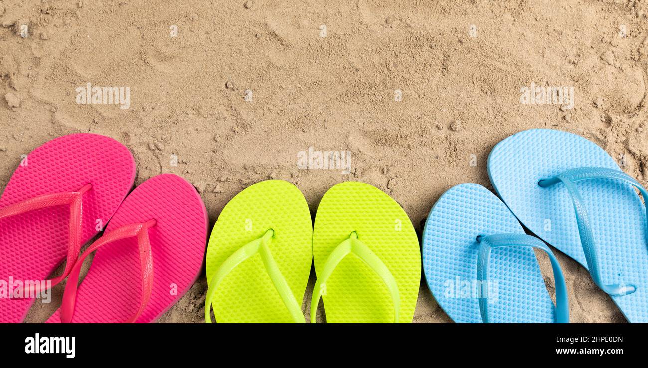 Top view of colorful flip flops in sand, summer and vacation concept ...