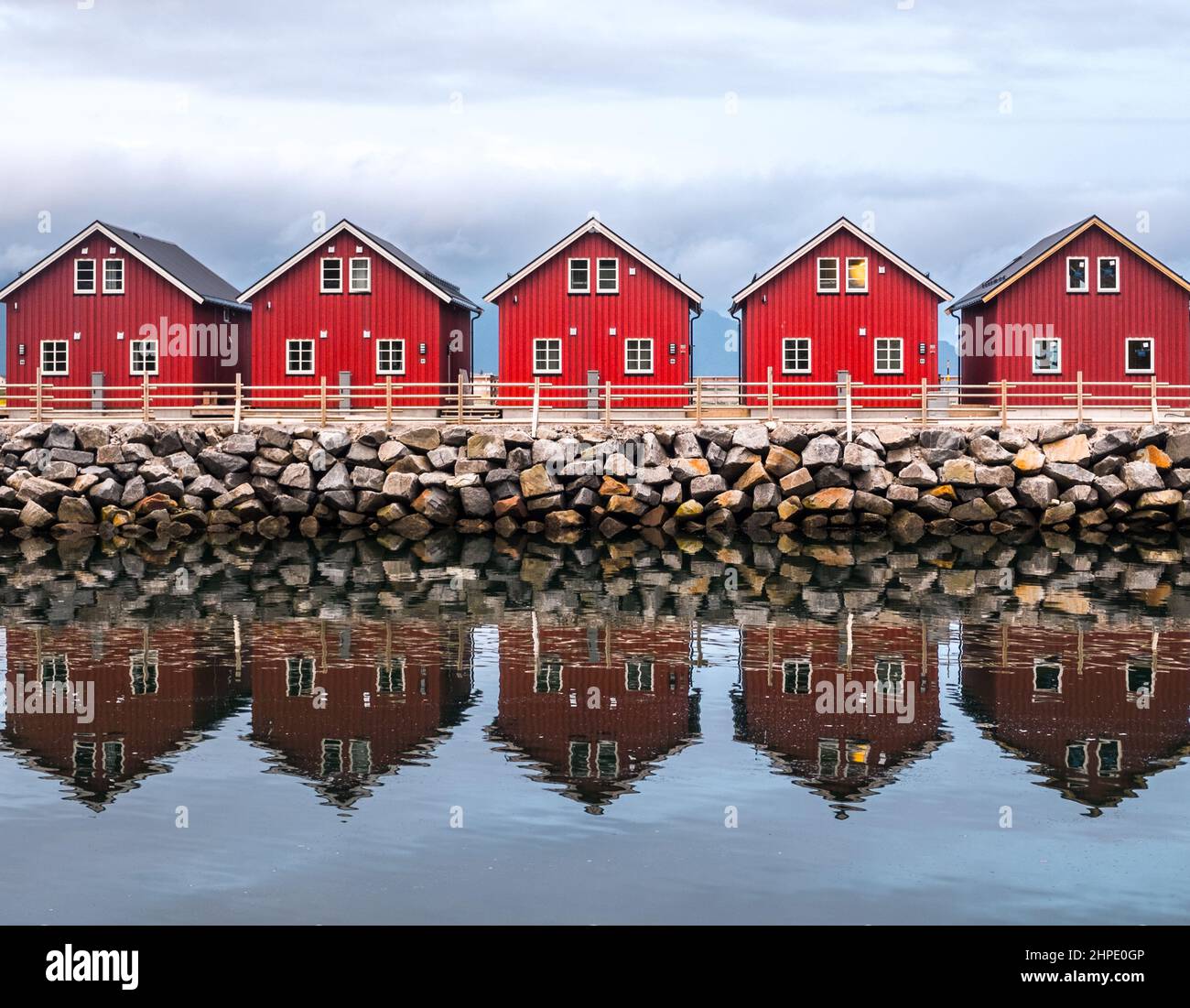 Beautiful view of classic red fishing cottages reflecting on the water ...