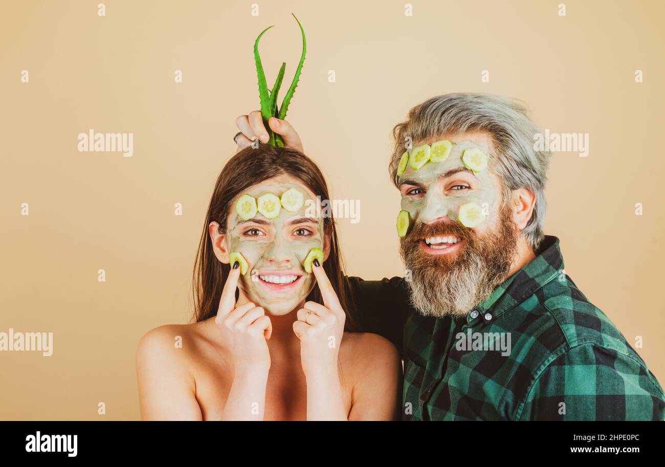 Funny couple with cucumbers mask on face. Girl with facial skincare ...