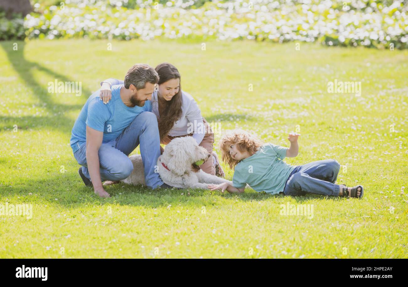 Beautiful happy family is having fun with dog outdoors. Cute family ...