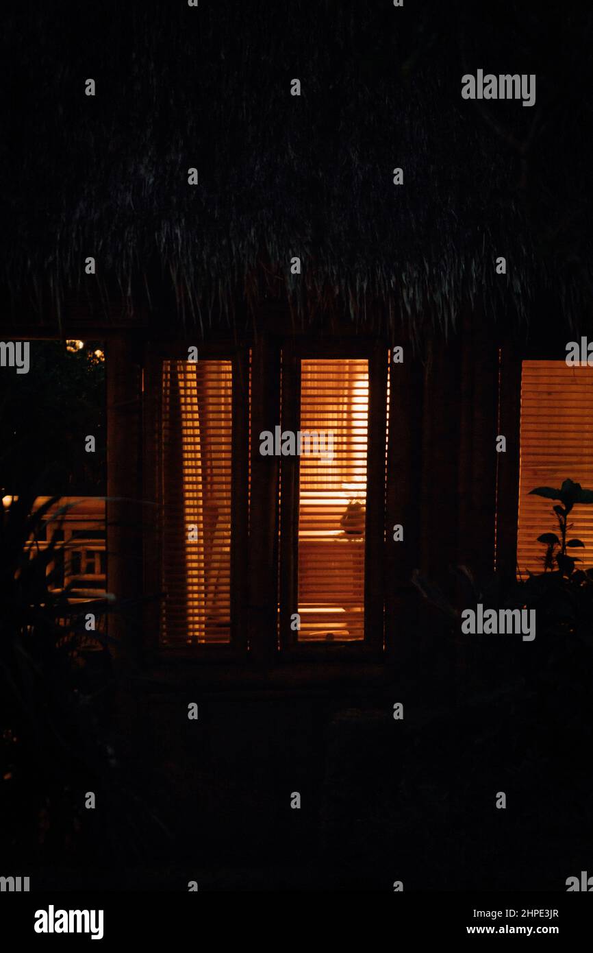 Cozy hut with warm light a seen through a jalousie door Stock Photo - Alamy