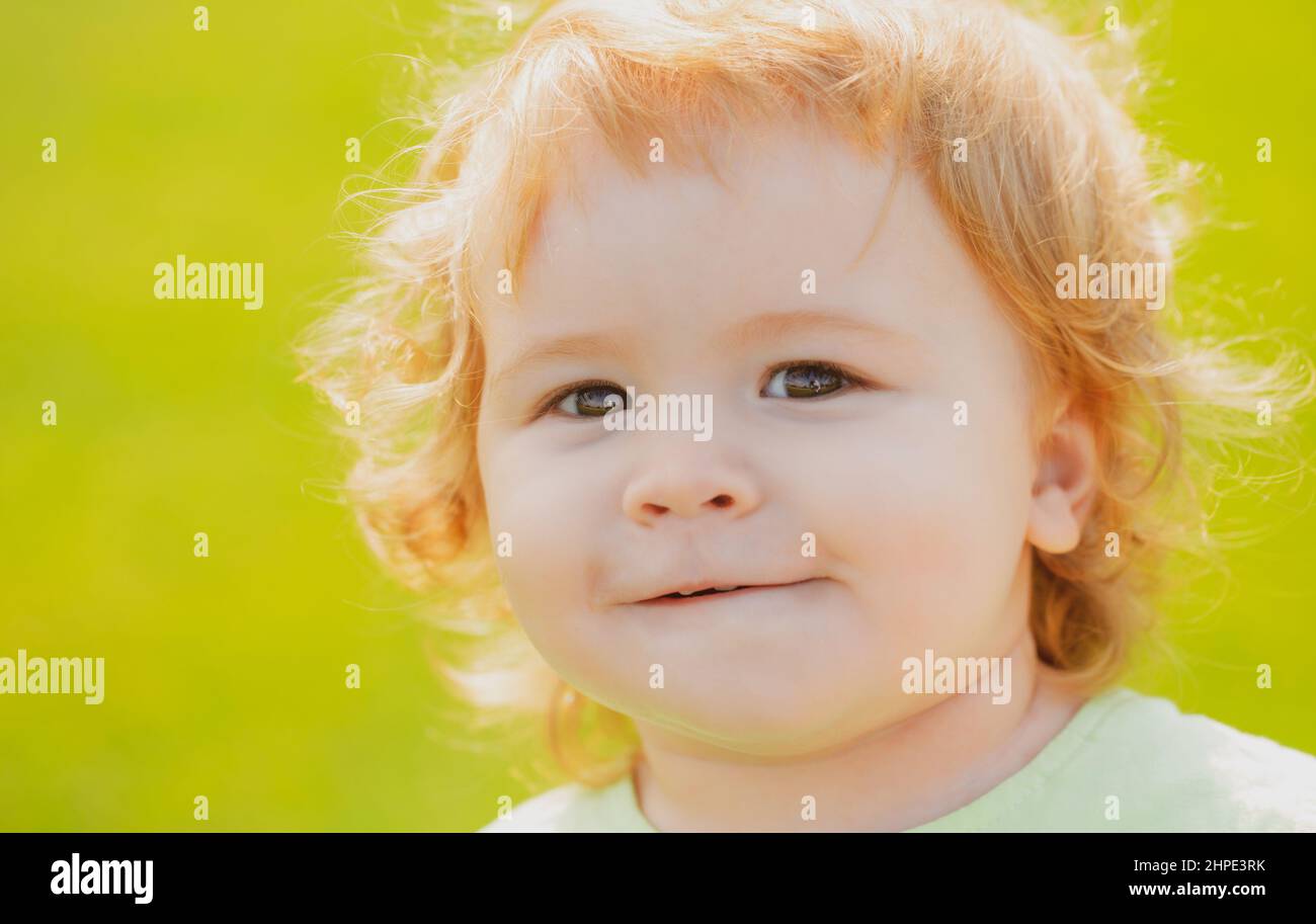 Close up portrait of a blond baby. Funny kids face in summer nature ...