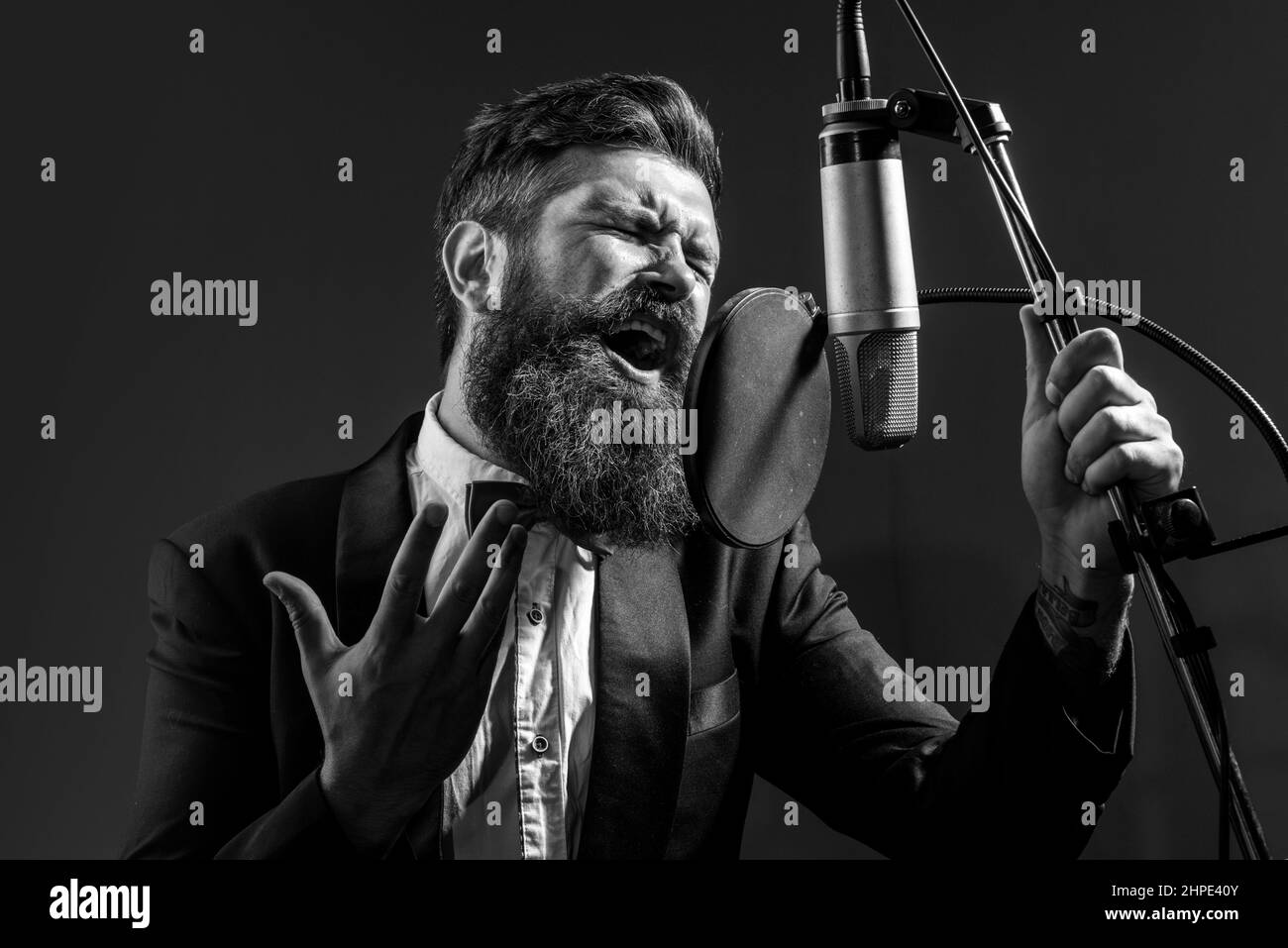 Singing man in a recording studio. Expressive bearded man with ...