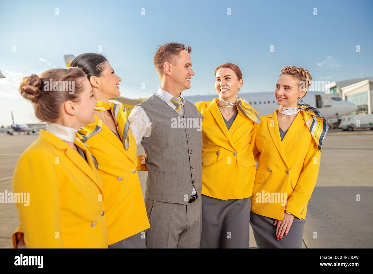 Joyful airline workers standing outdoors at airfield Stock Photo - Alamy