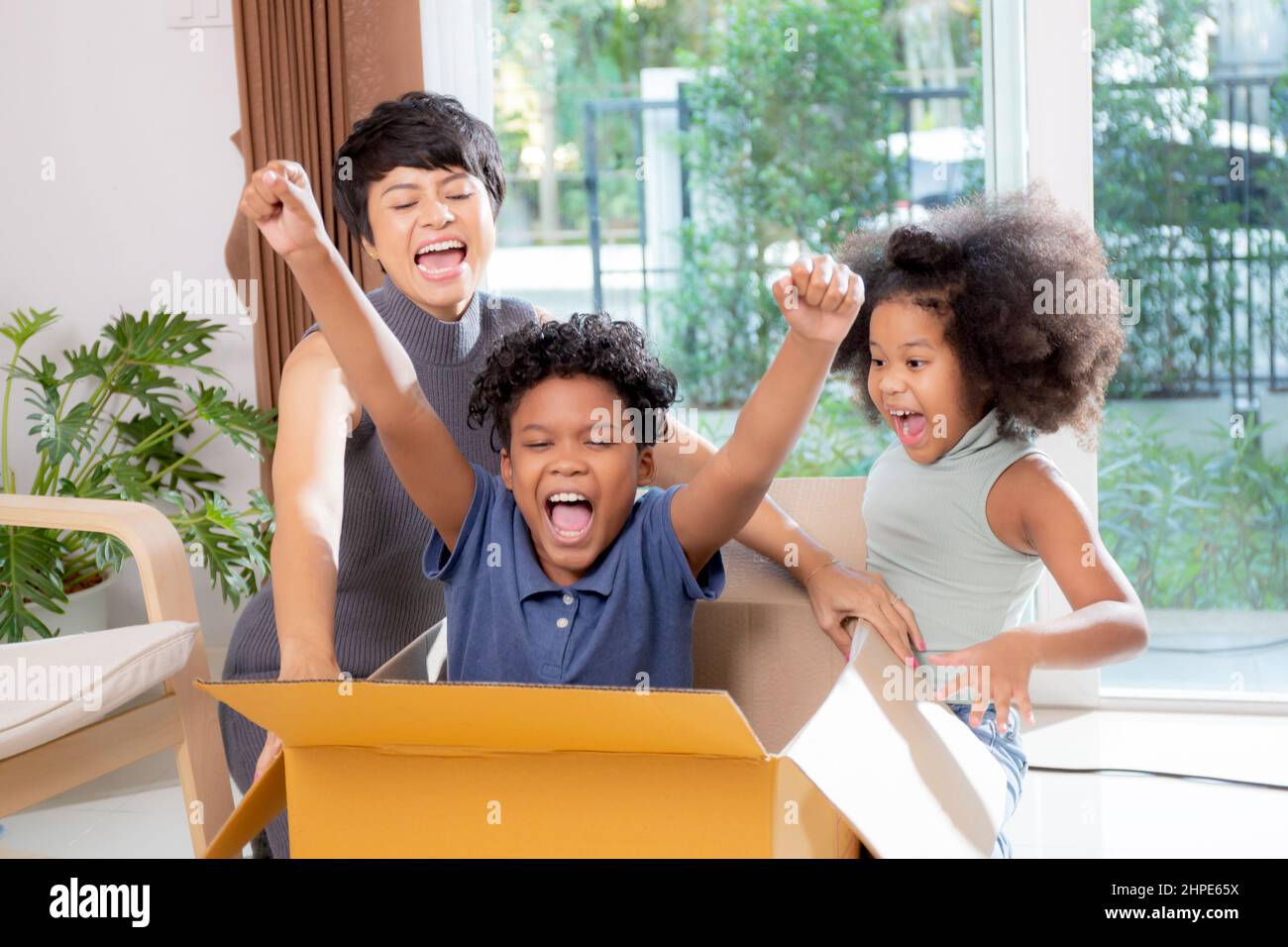 Happiness African family with mother and daughter pushing cardboard box ...